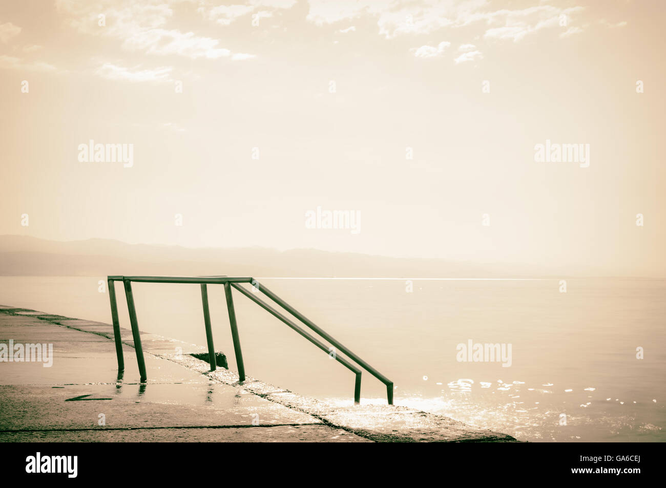 Old iron ladder for swimming on the shore Stock Photo - Alamy