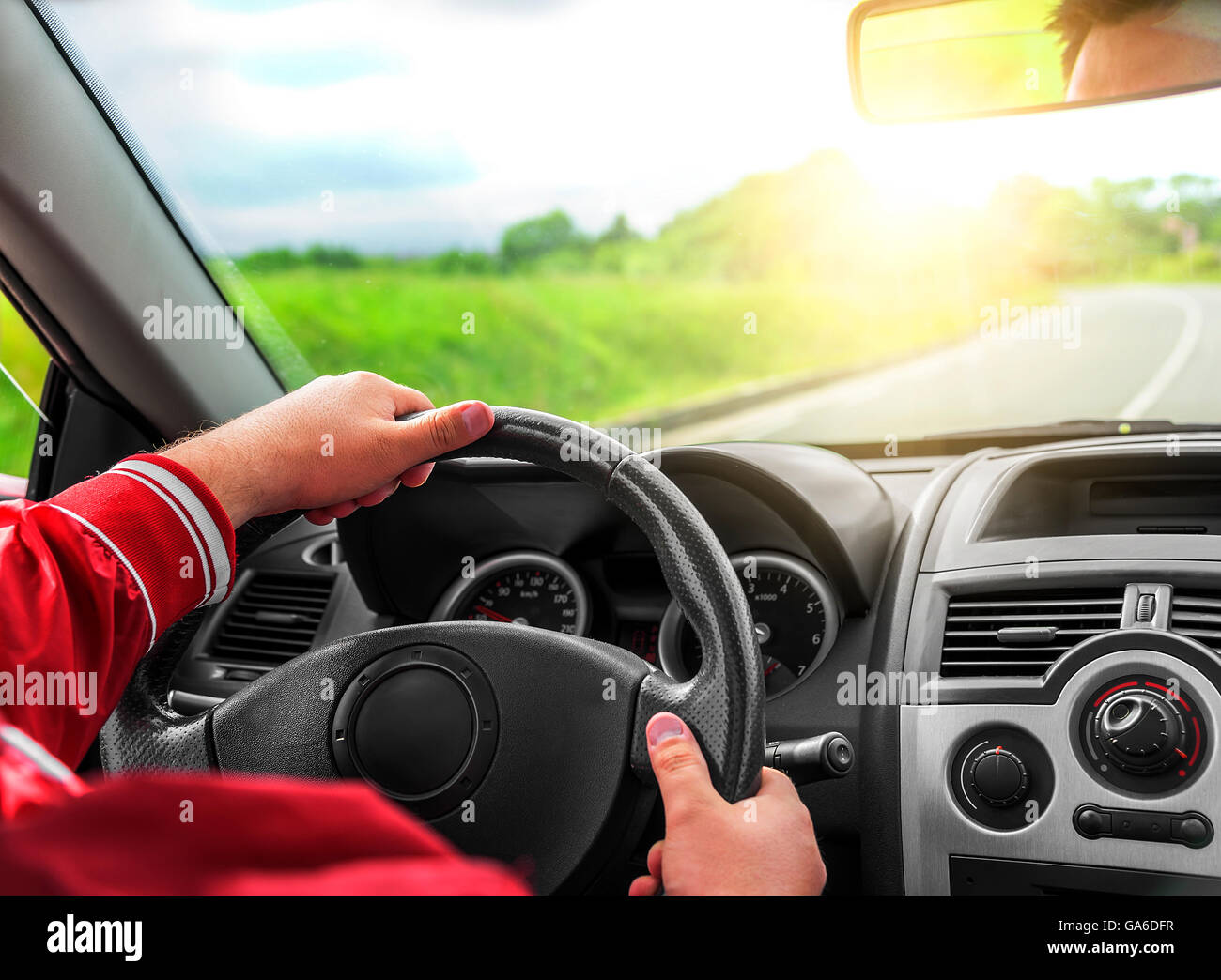 Male driver drives a car on the country road. The view from the cabin ...