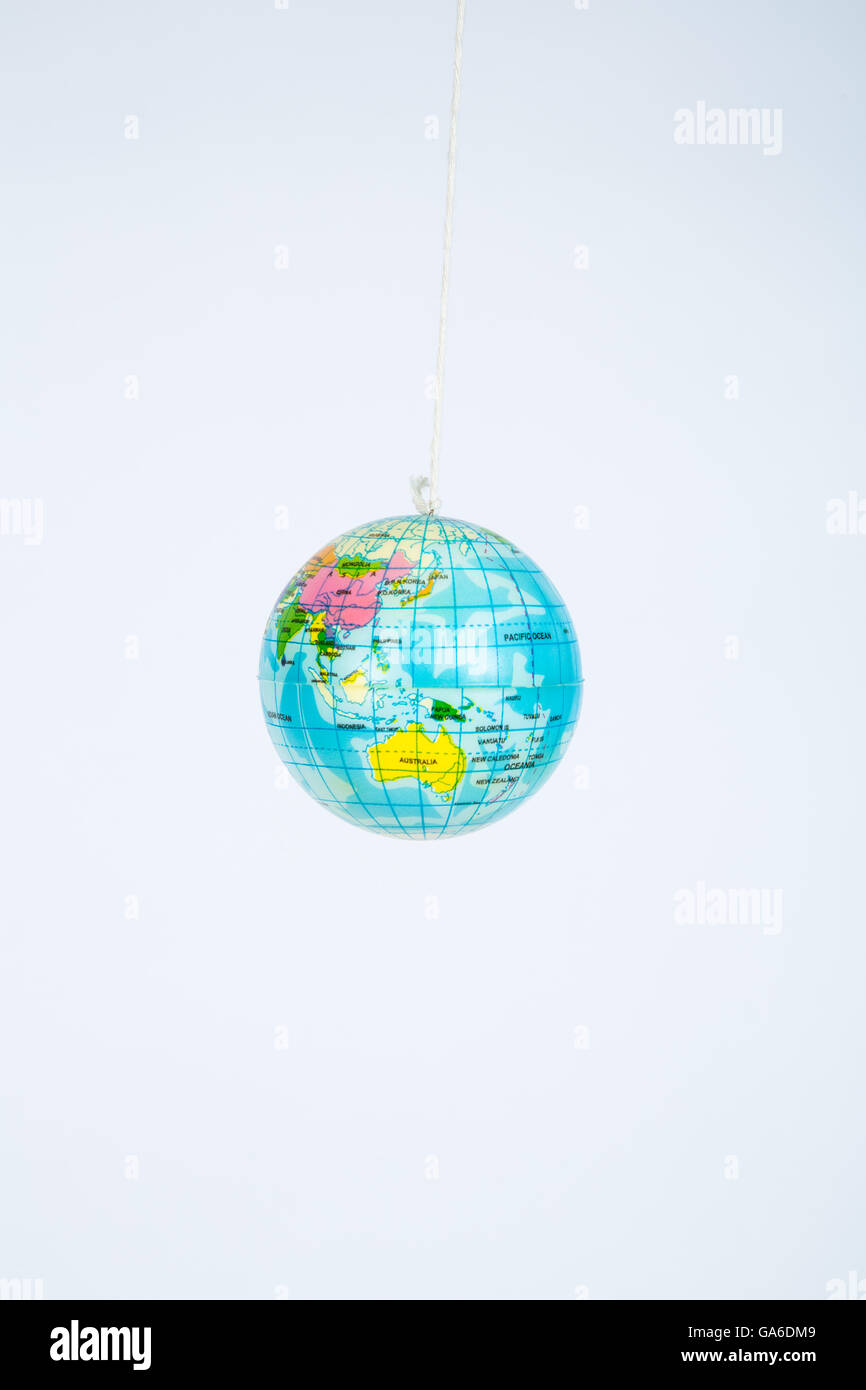A small toy globe suspended on a string Stock Photo - Alamy