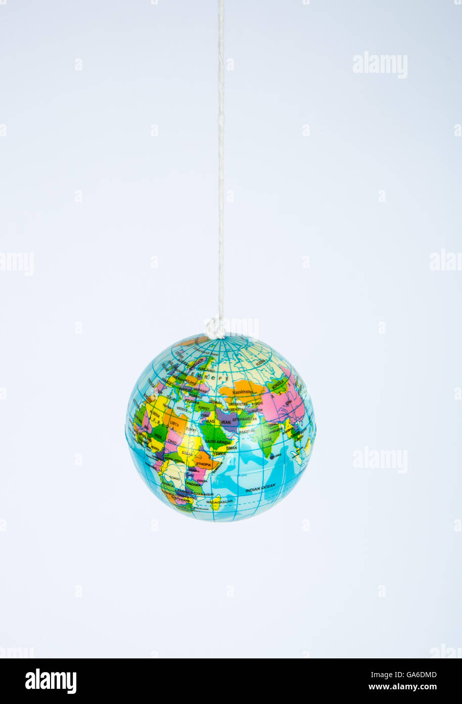 A small toy globe suspended on a string Stock Photo - Alamy