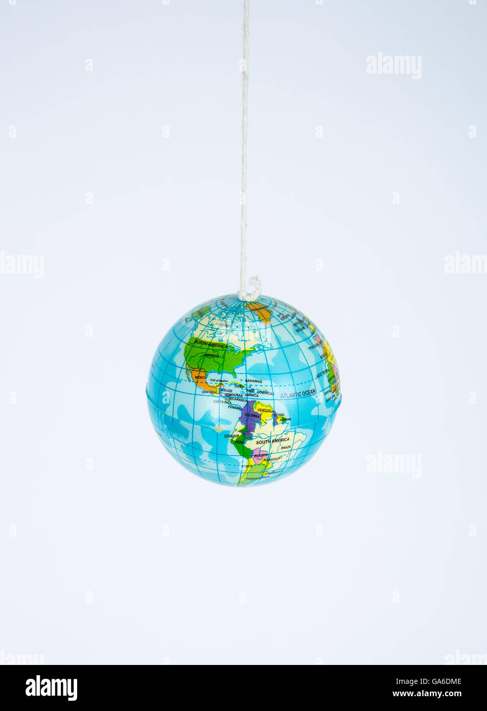 A small toy globe suspended on a string Stock Photo - Alamy