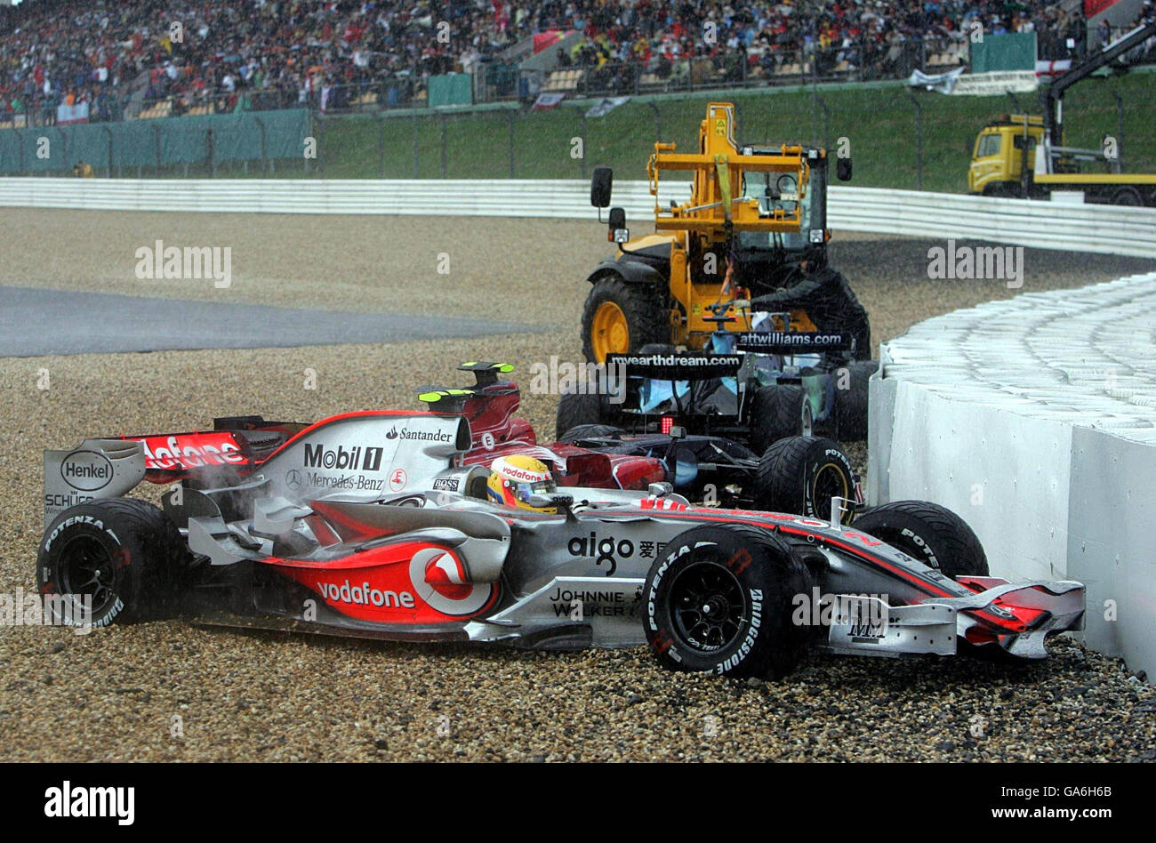 Great Britain's Lewis Hamilton sits on the gravel waiting to be lifted ...
