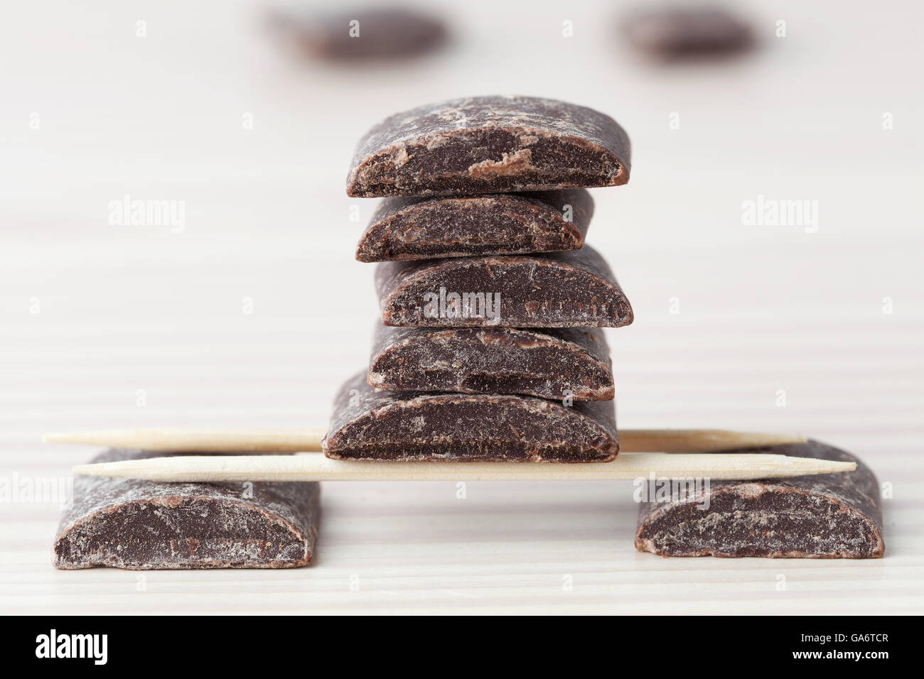 Dark cooking chocolate pieces arranged on wooden toothpicks with copy ...