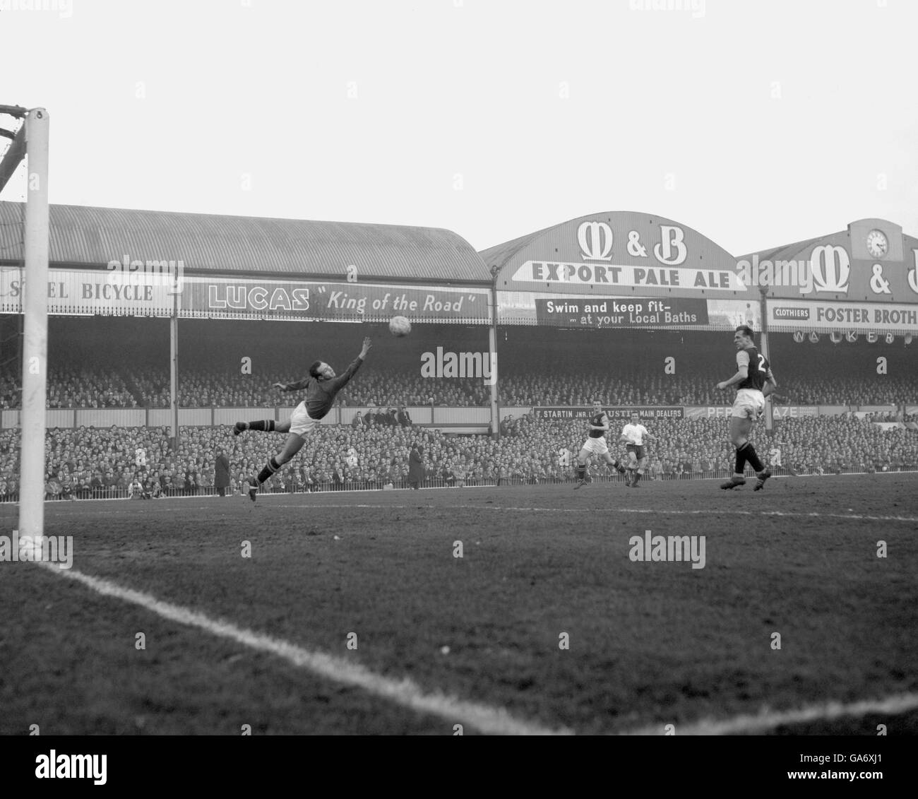 Geoff Sidebottom, the Aston Villa goalkeeper, leaps high into the air ...
