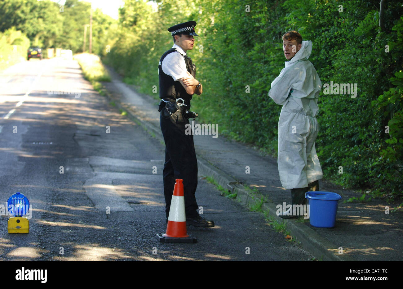 Police officers on Westwood Lane in Normandy, Surrey where a farm in ...
