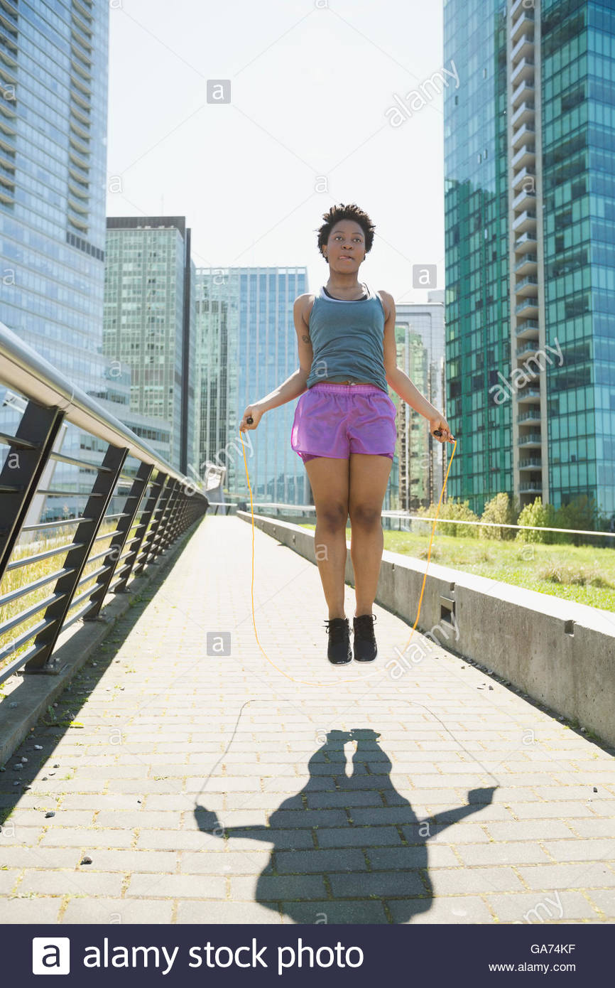 Woman jumping rope on city boardwalk Stock Photo - Alamy