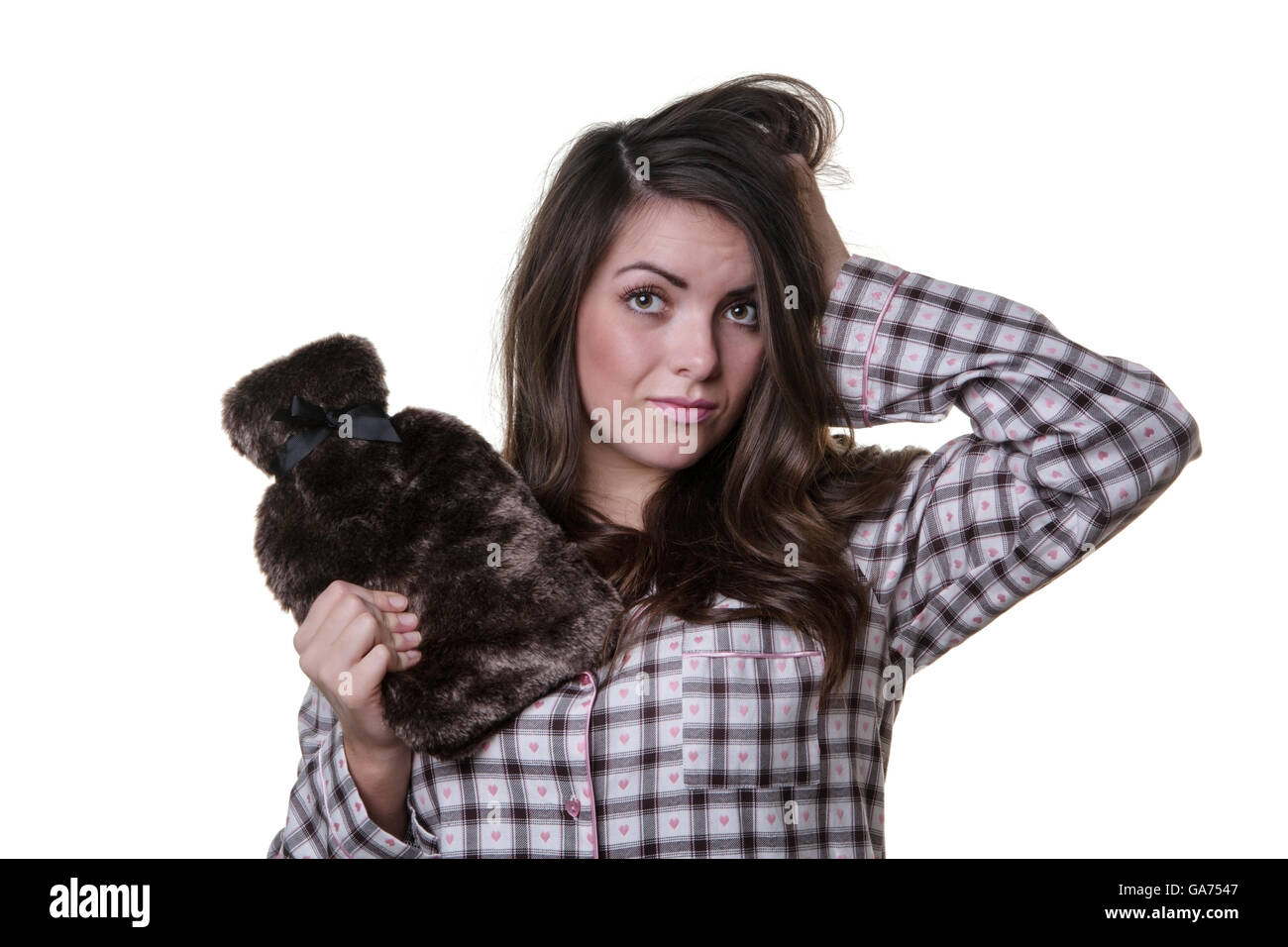 Studio shot of a tired, sleepy looking model wearing her pyjamas and ...