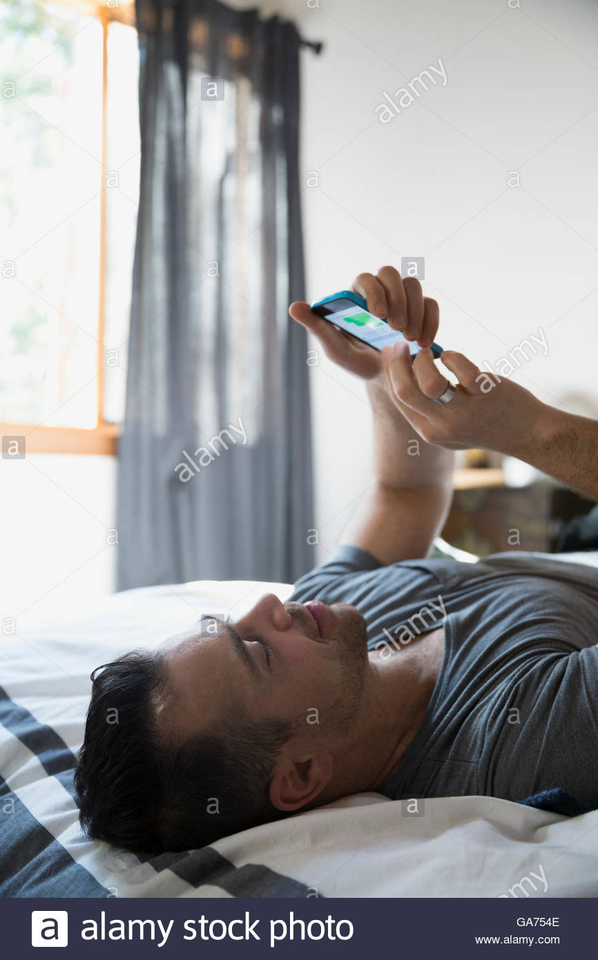 Man laying on bed texting hi-res stock photography and images - Alamy