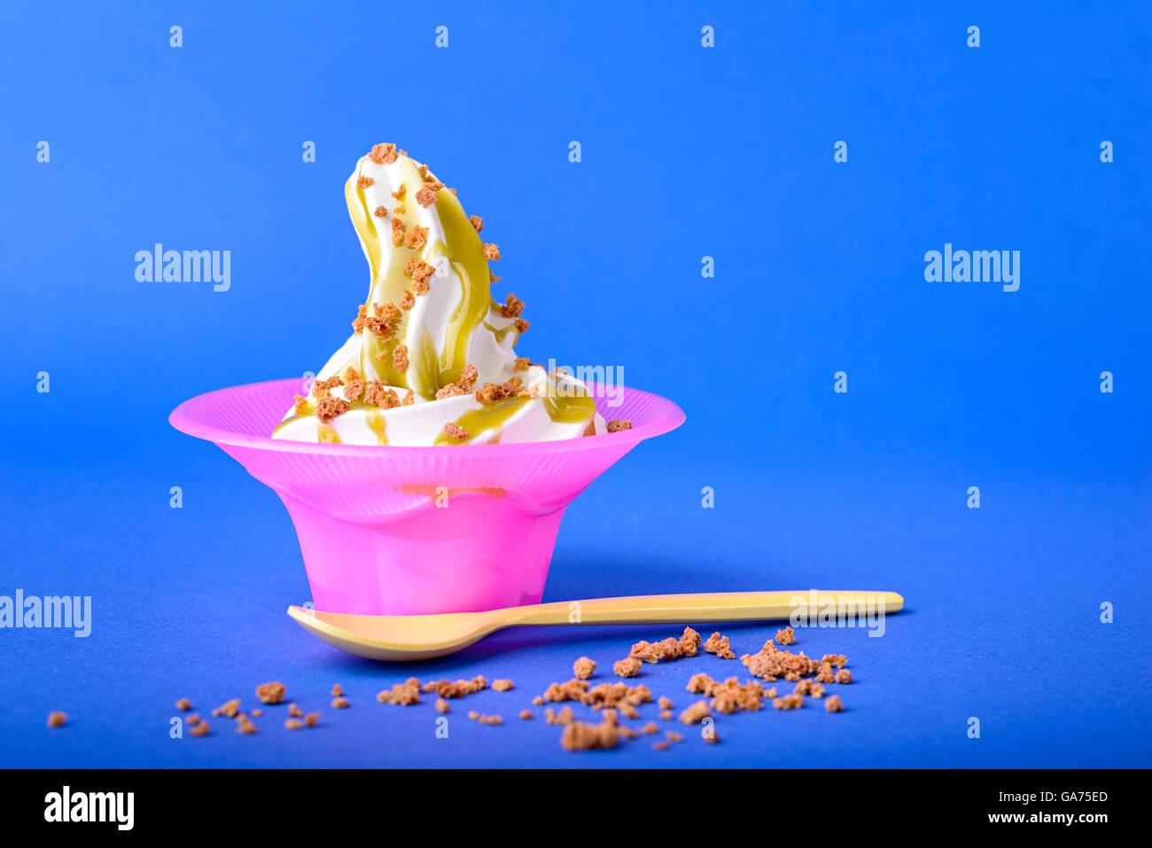 frozen yogurt with green topping and crushed amaretti in pink bowl on ...