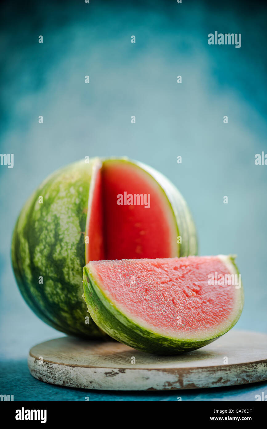 whole watermelon with cut off slice on wooden board Stock Photo - Alamy