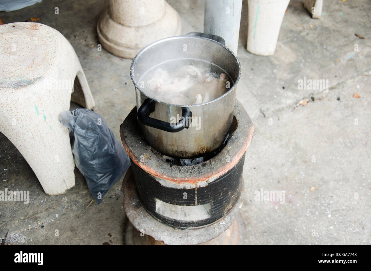 Boil chicken bone, foot and pork bone for cooking soup stock on Stove ...