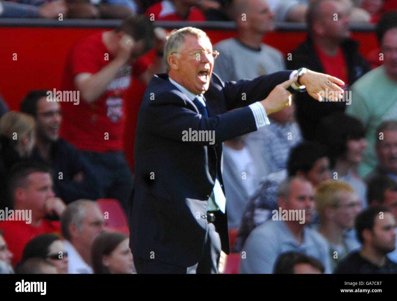 Manchester United manager Alex Ferguson points to his watch on the ...