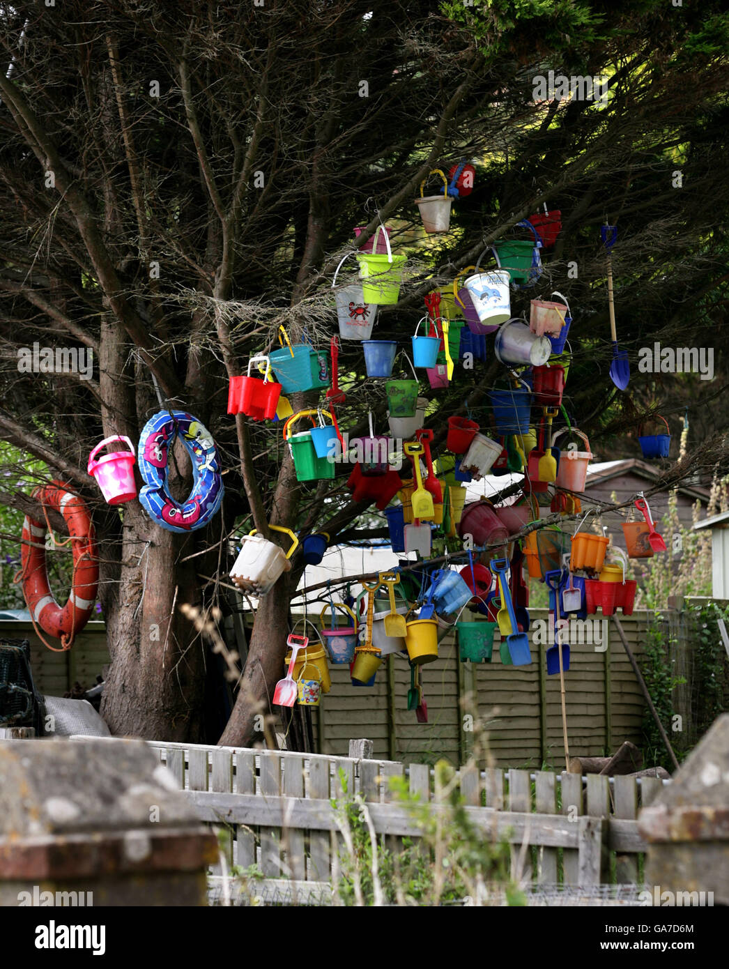 Buckets and spades are seen in a tree near the beach at Lulworth Cove ...