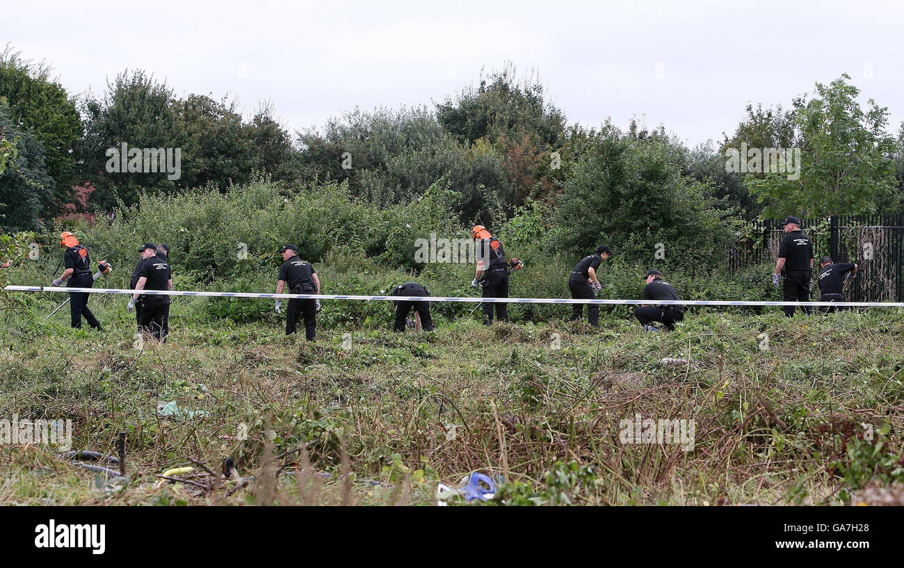 Police officers search the scene behind the Fir Tree pub in Croxteth ...