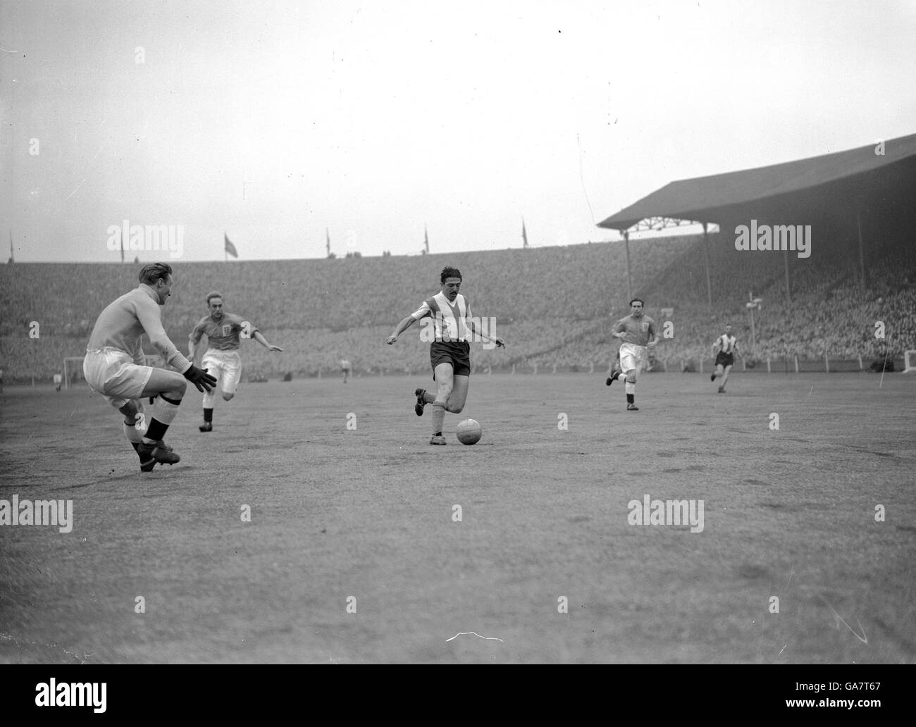 Argentina's Angel Labruna (c) rounds England goalkeeper Bert Williams ...