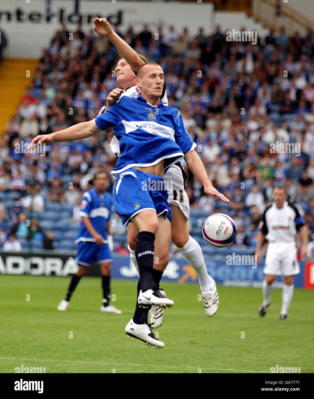 Rotherham's Stephen Brogan challenges Stockport's David Poole for the ...