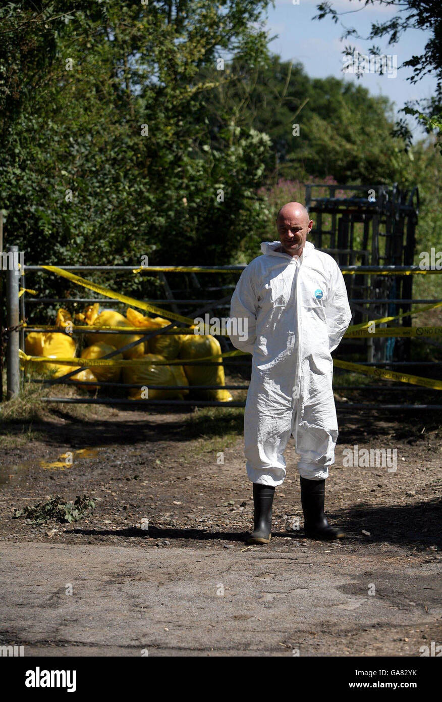 A member of the DEFRA response team stands outside a farm in Flexford ...