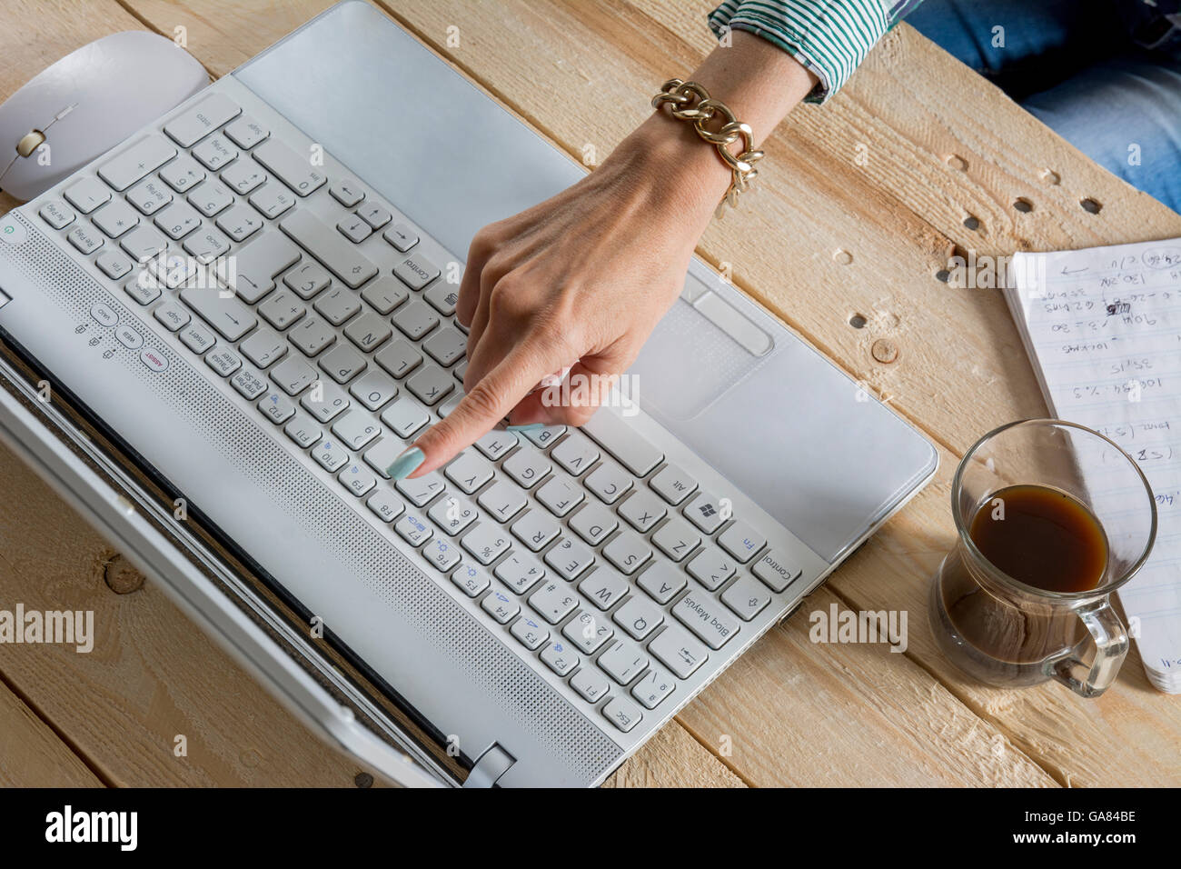 Woman at the computer, pointing to the screen, wearing plaid shirt and ...