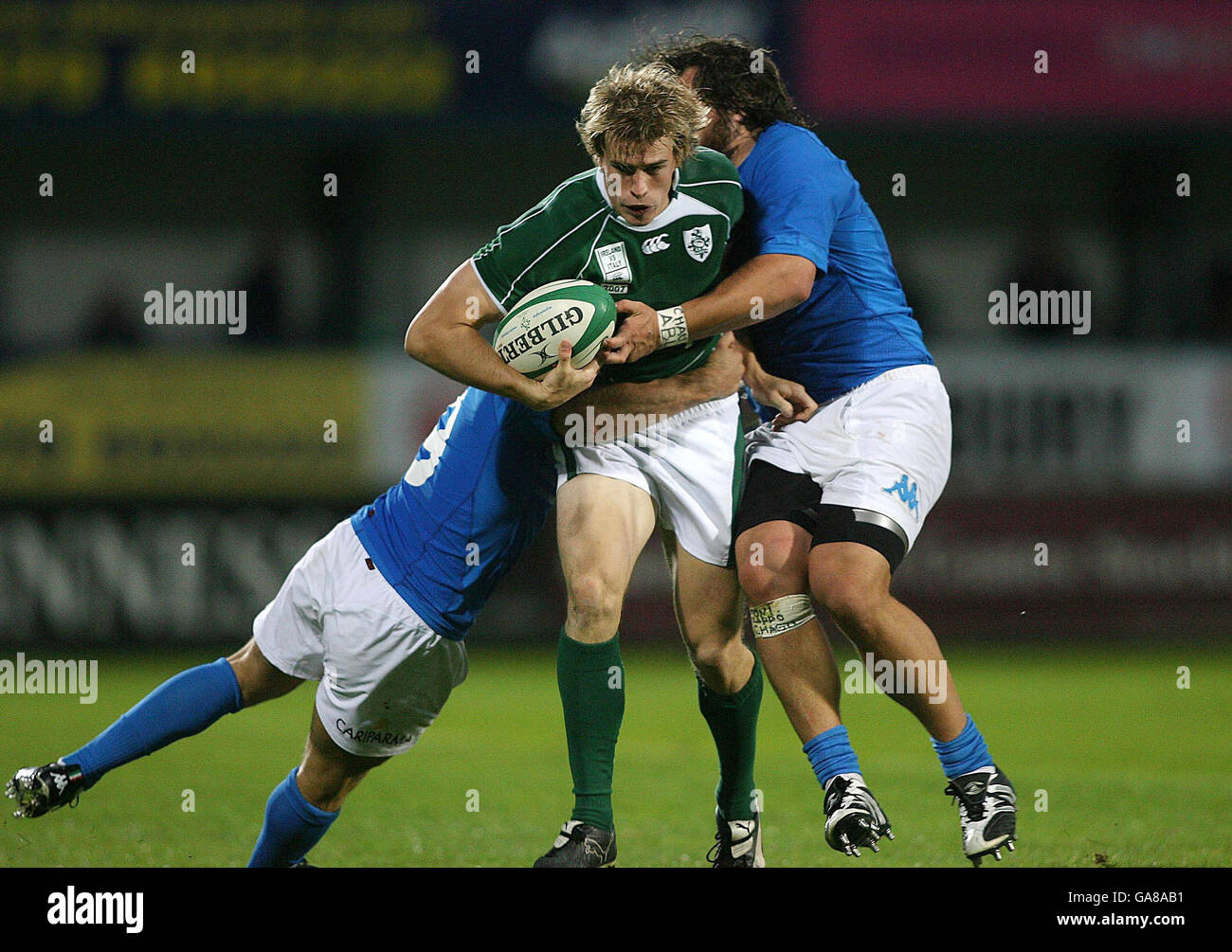 Ireland's Andrew Trimble is tacked by Italy's Alessandro Troncon (left ...