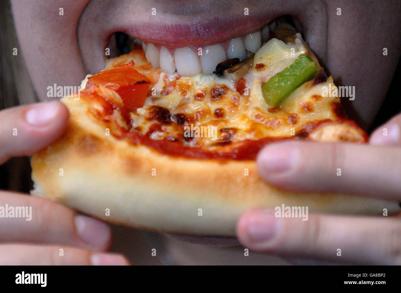 Generic photo of a woman biting into a slice of pizza from Pizza Hut ...