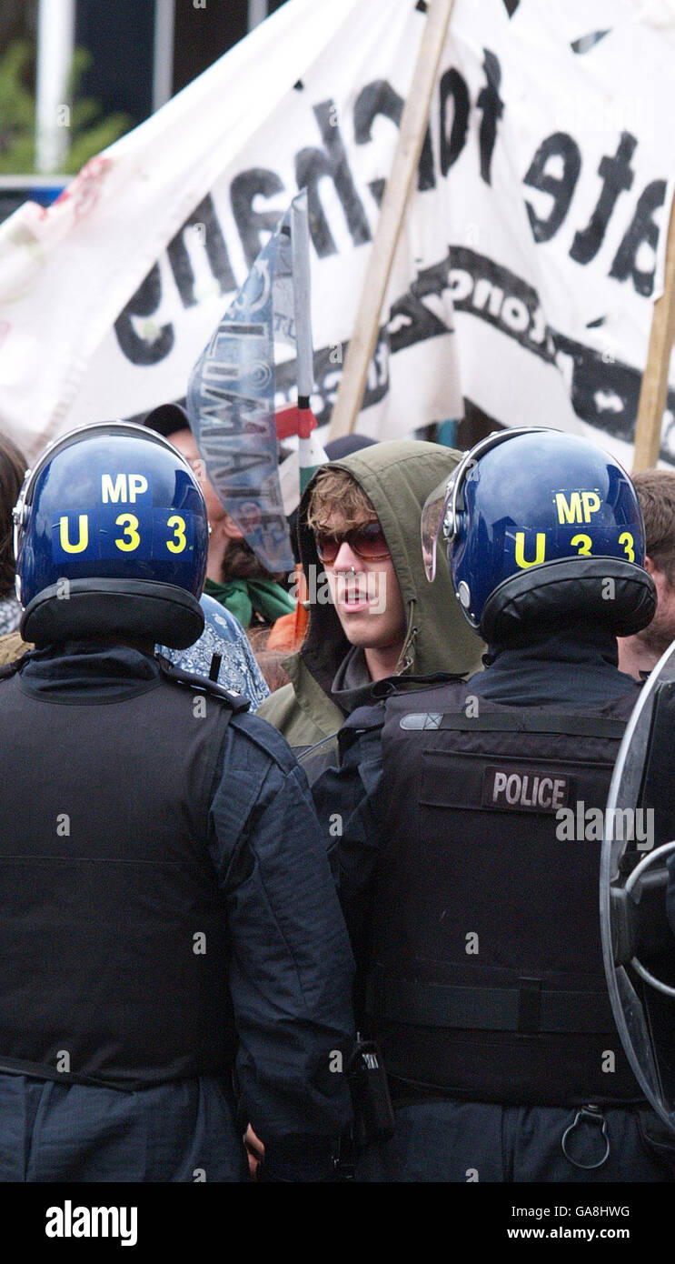 A climate change demonstrater and riot police face each other outside ...