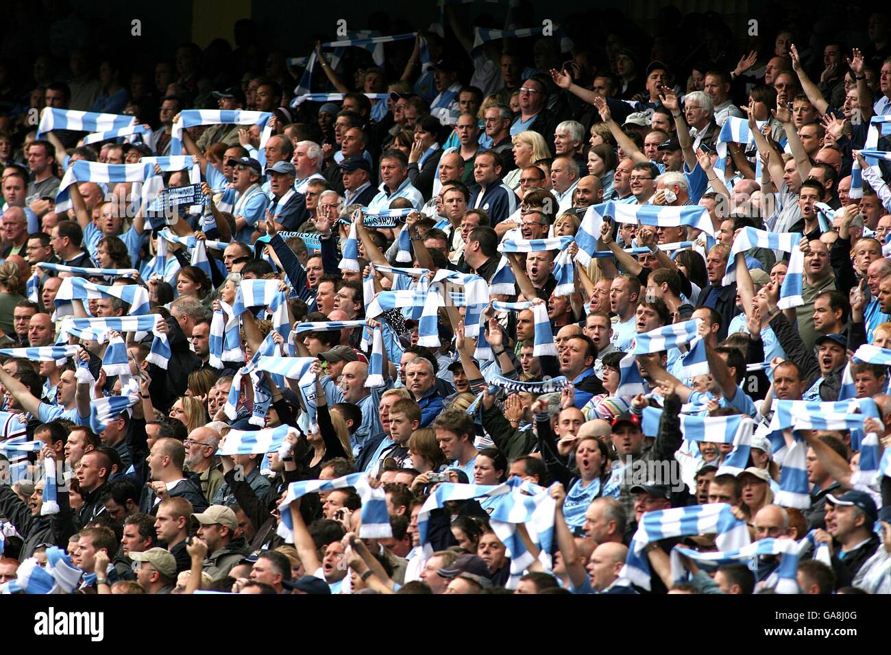 Manchester city fans cheer on their team from the stands hi-res stock ...