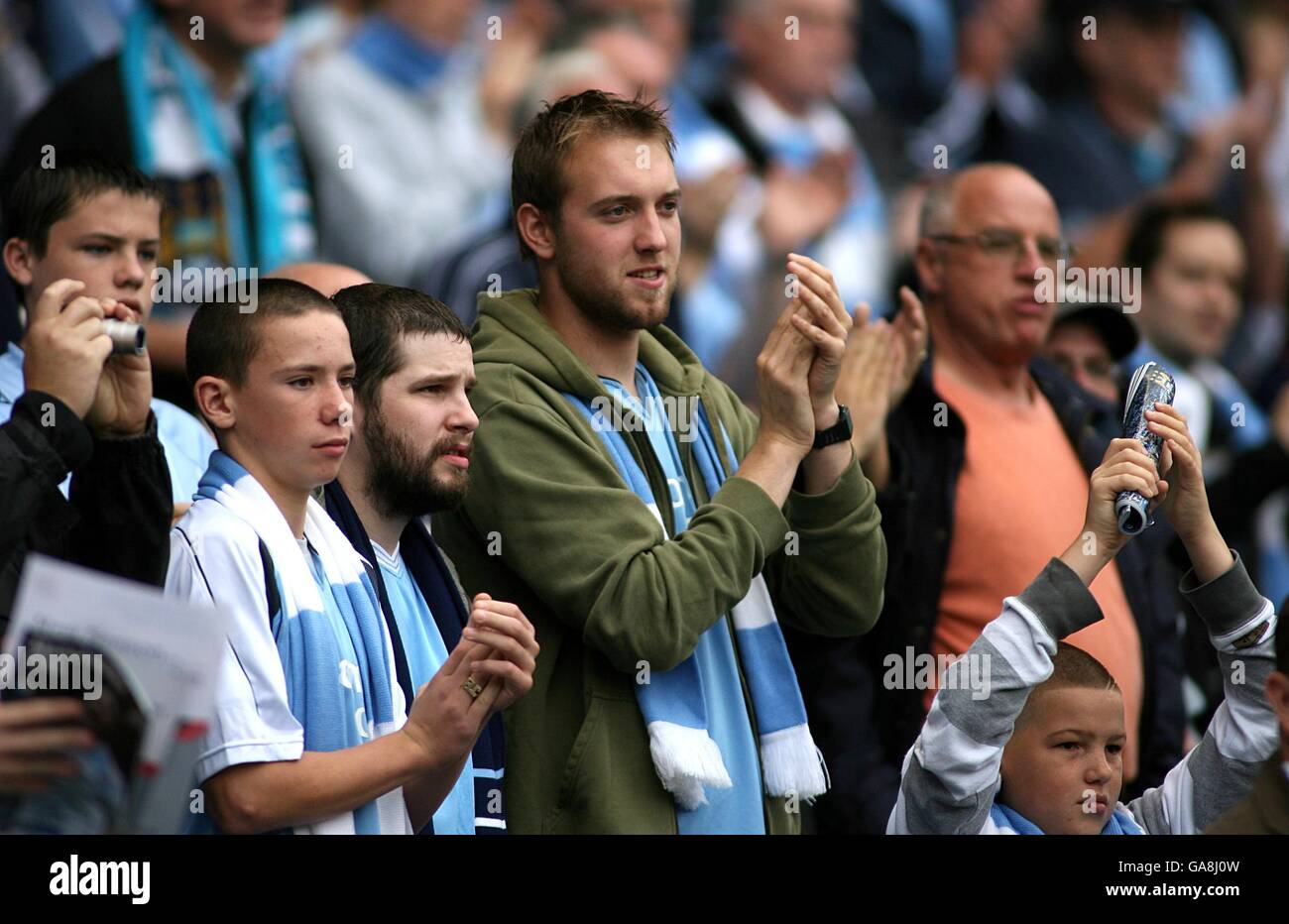 Manchester city fans cheer on their team from the stands hi-res stock ...
