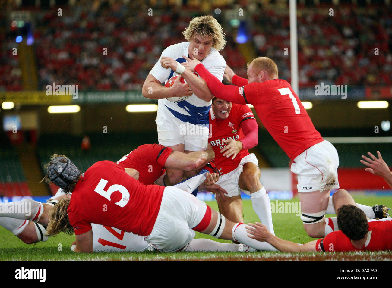 France's Remy Martin is held up by Wales's Martyn Williams during the ...