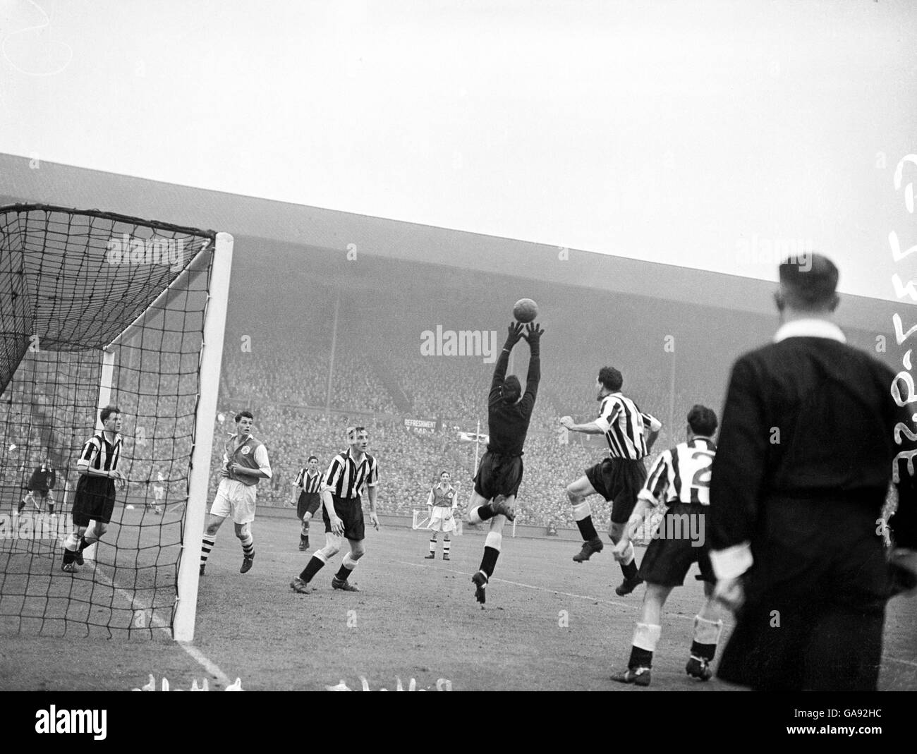 Newcastle United goalkeeper Ronnie Simpson (fourth l) leaps to ...