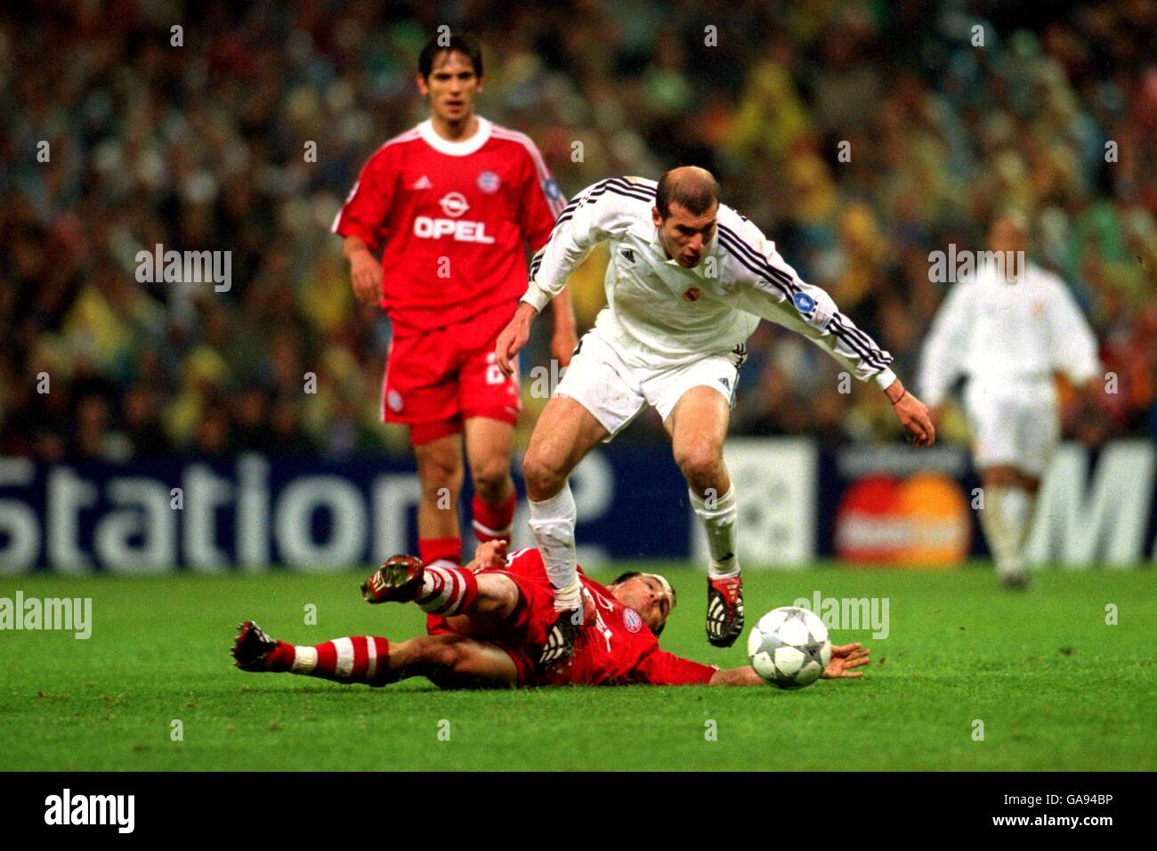 Real Madrid's Zinedine Zidane (top) jumps the tackle of Bayern Munich's ...
