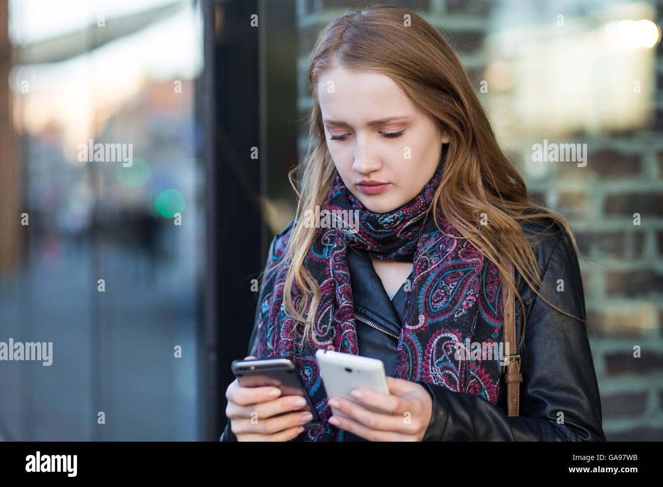 Girl holding two mobile phones Stock Photo - Alamy