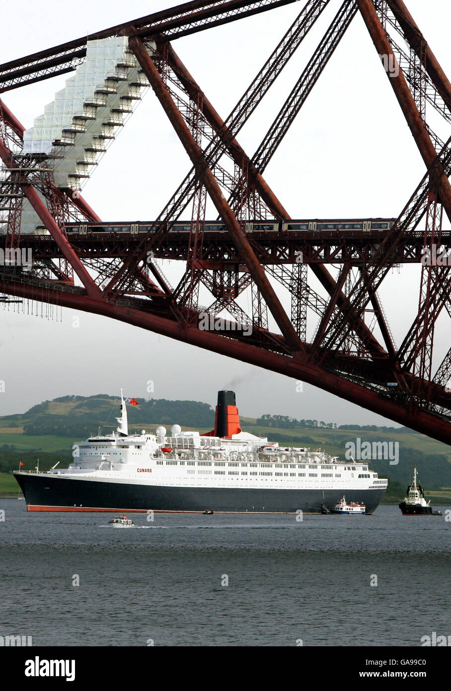 The QE2 moores in the River Forth beside the Forth Rail Bridge during ...