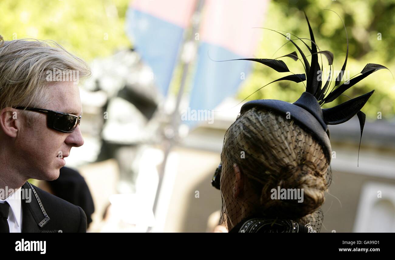 Philip Tracy looks at an atendee wearing one of his hats at the ...
