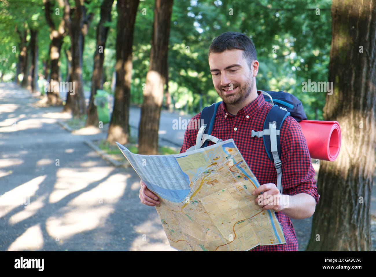 Man with a map exploring outdoors Stock Photo - Alamy