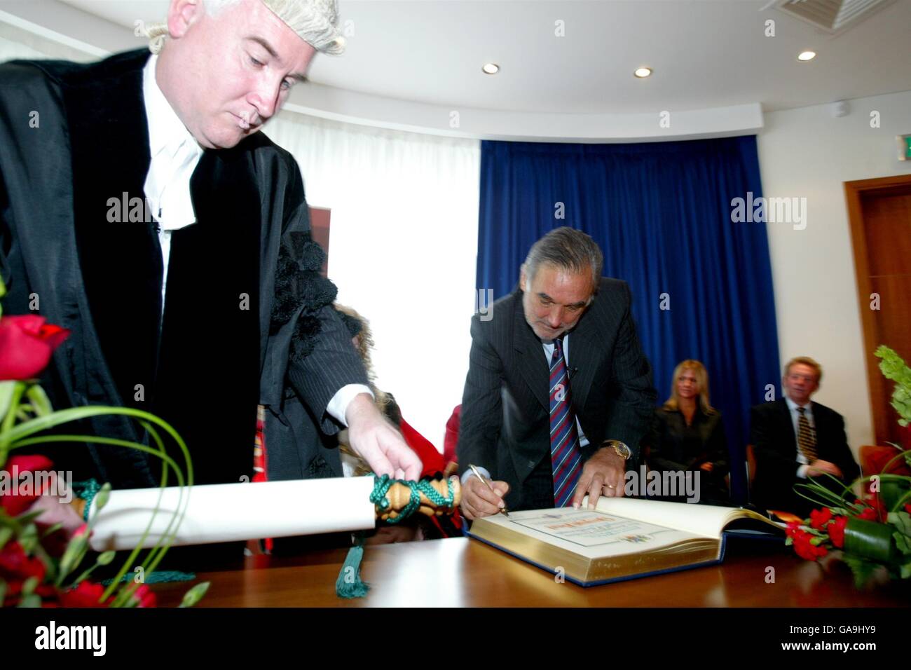 George Best signs his name after he recieved the freedom of the Borough ...