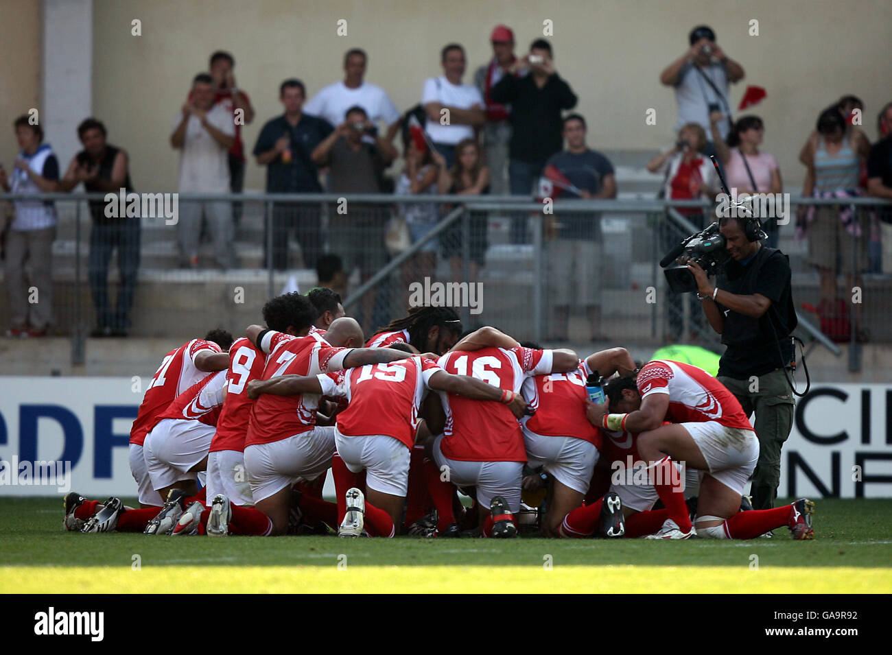 Tongan players sink to their knees to pray at the final whistle Stock ...