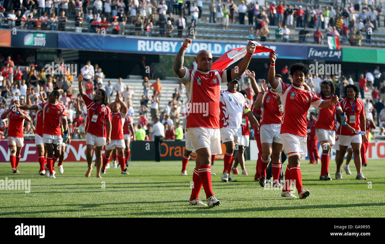 Tonga's Nili Latu and Enele Taufa carry a tongan flag as they do a lap ...