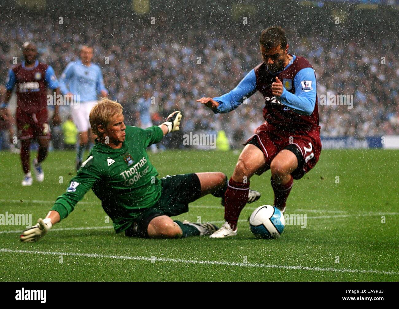 Manchester City goalkeeper Kasper Schmeichel saves at the feet of Aston ...