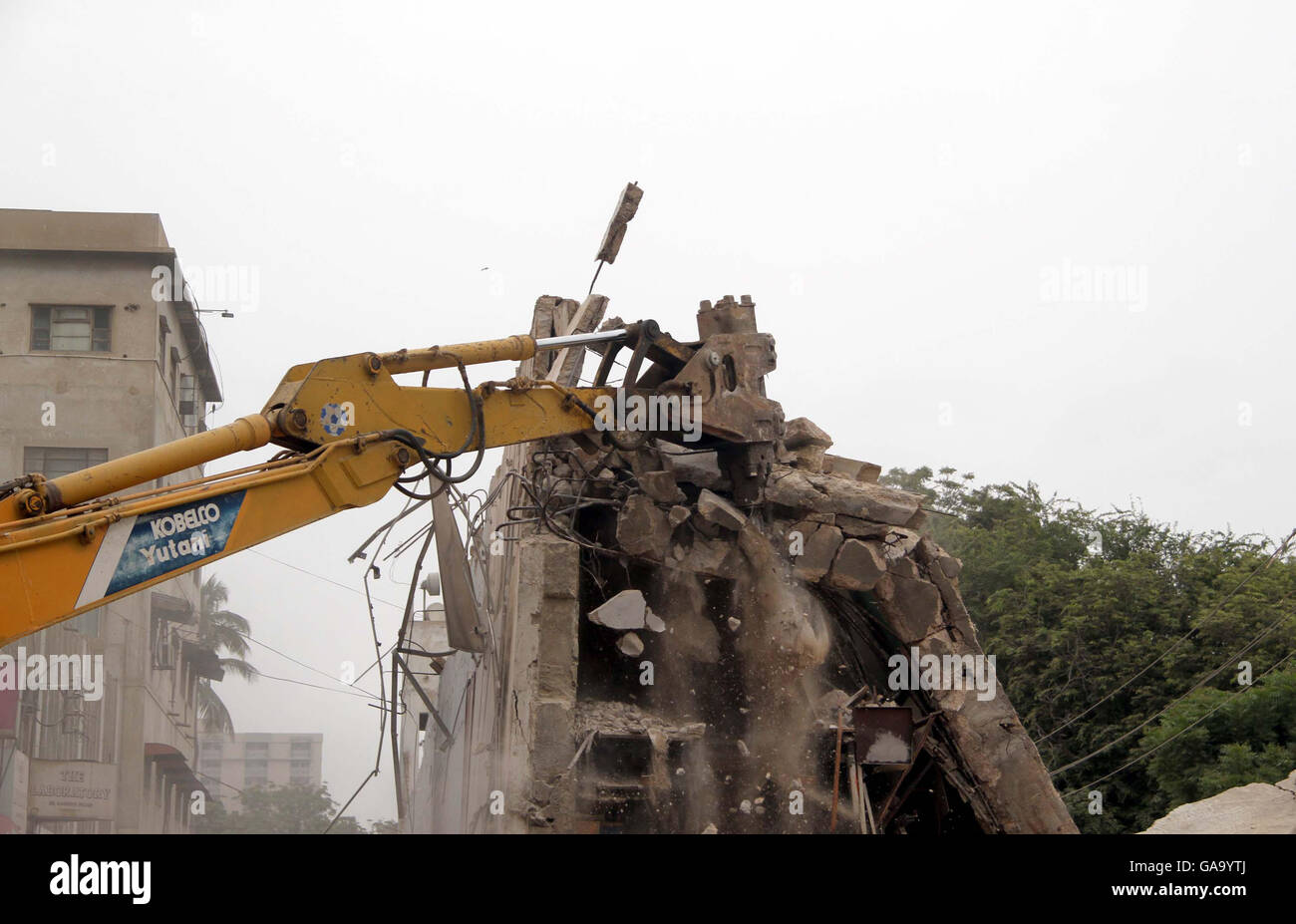 Heavy machinery demolishing remaining part of building which collapsed ...