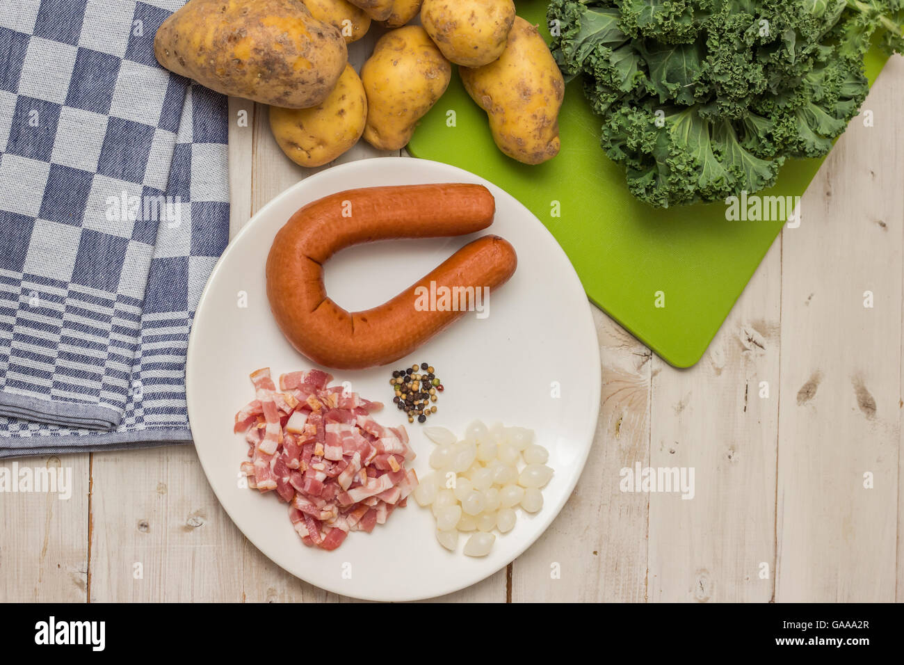 Ingredients to make typical dutch boerenkool with kale, sausage, bacon ...