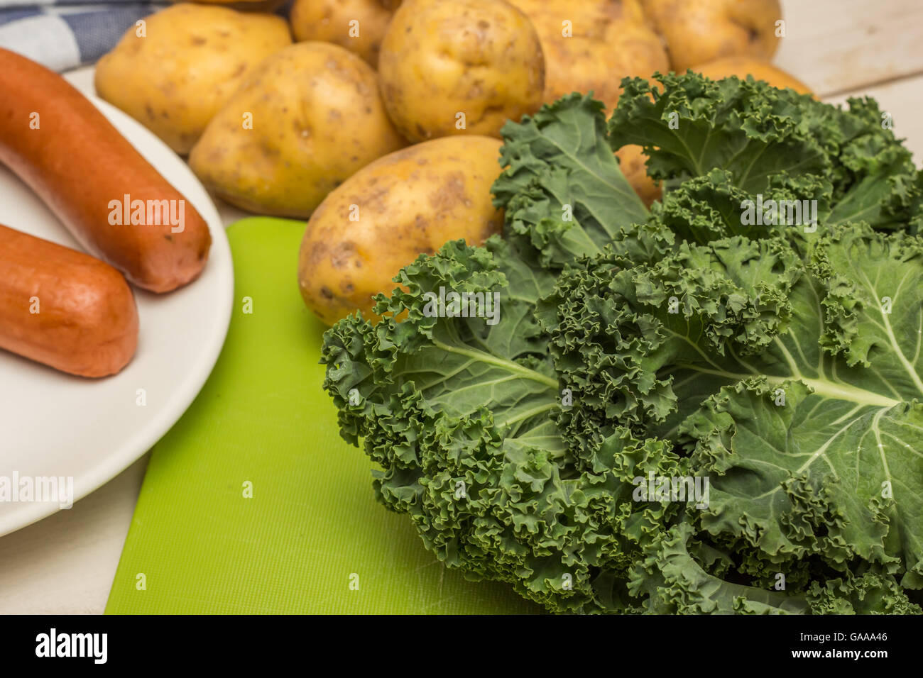 Ingredients to make typical dutch boerenkool with kale, sausage, and ...