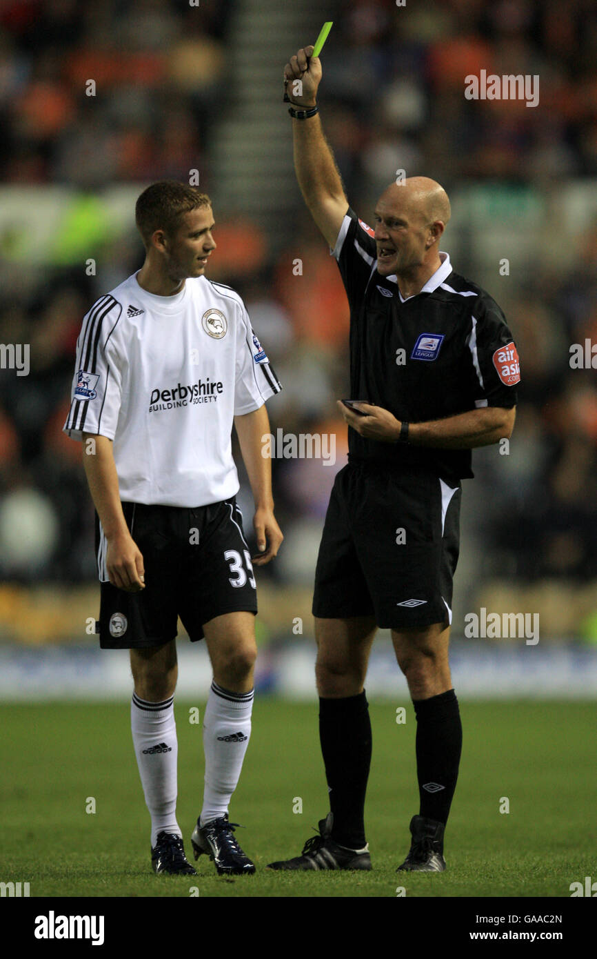 Referee Nigel Miller brandishes a yellow card to Derby County's Jason ...