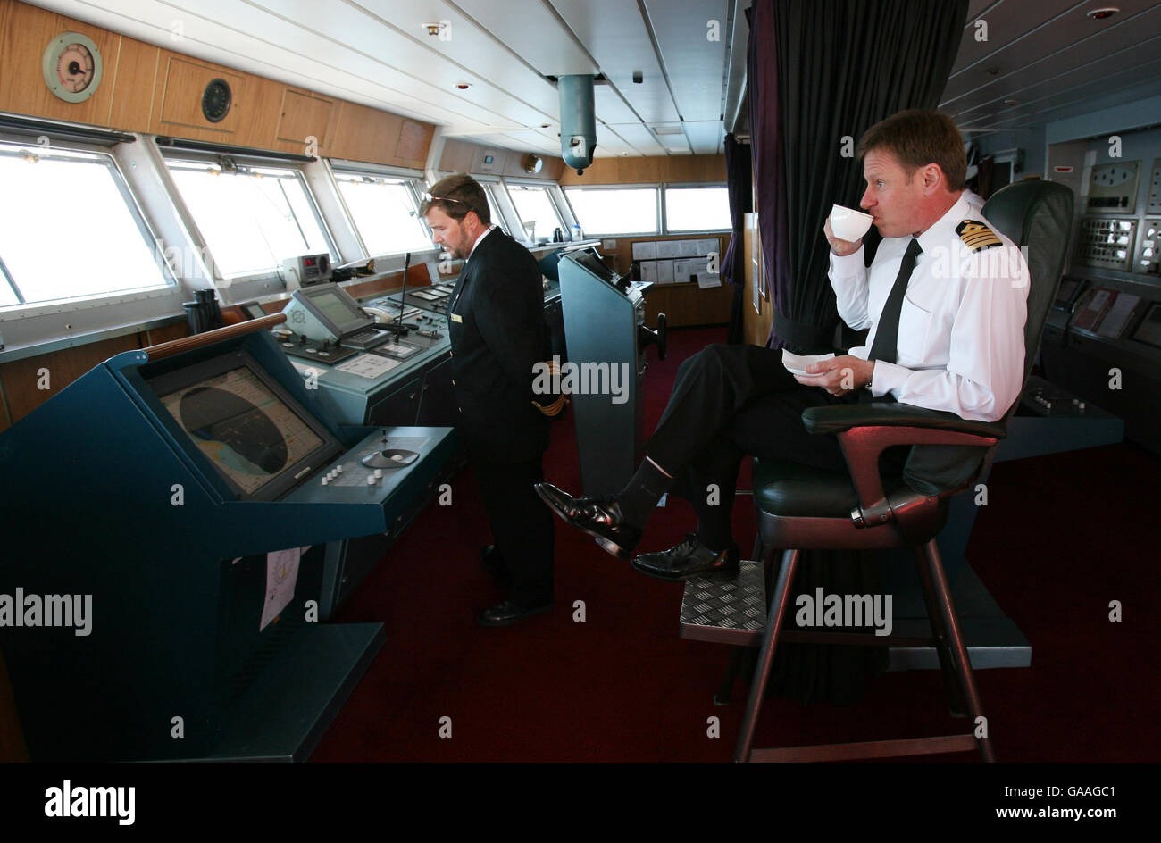 QE2 Captain Ian McNaught monitors the Bridge as the QE2 sails to ...