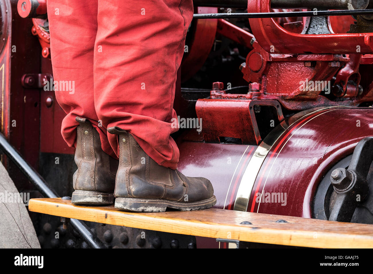 The leather boots of a worker as he stands next to a steam engine Stock ...