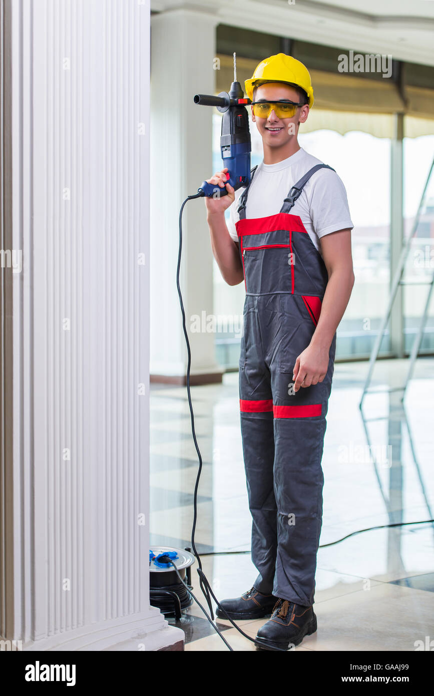 Man drilling the wall with drill perforator Stock Photo - Alamy