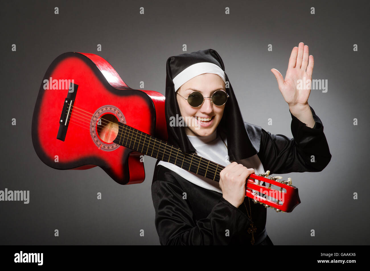 Funny nun with red guitar playing Stock Photo - Alamy