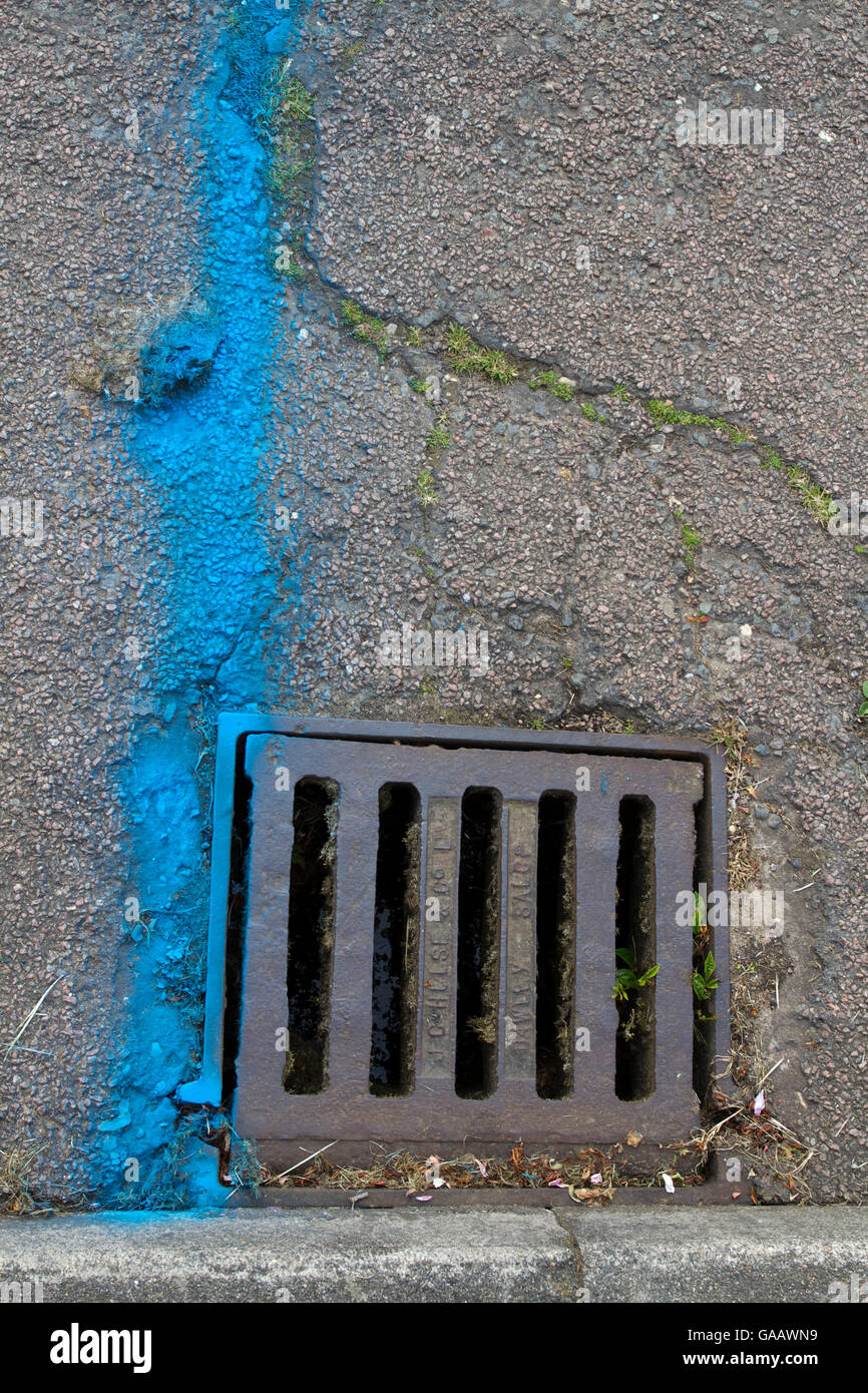 Blue line sprayed on to road surface by a drain as a road race start ...