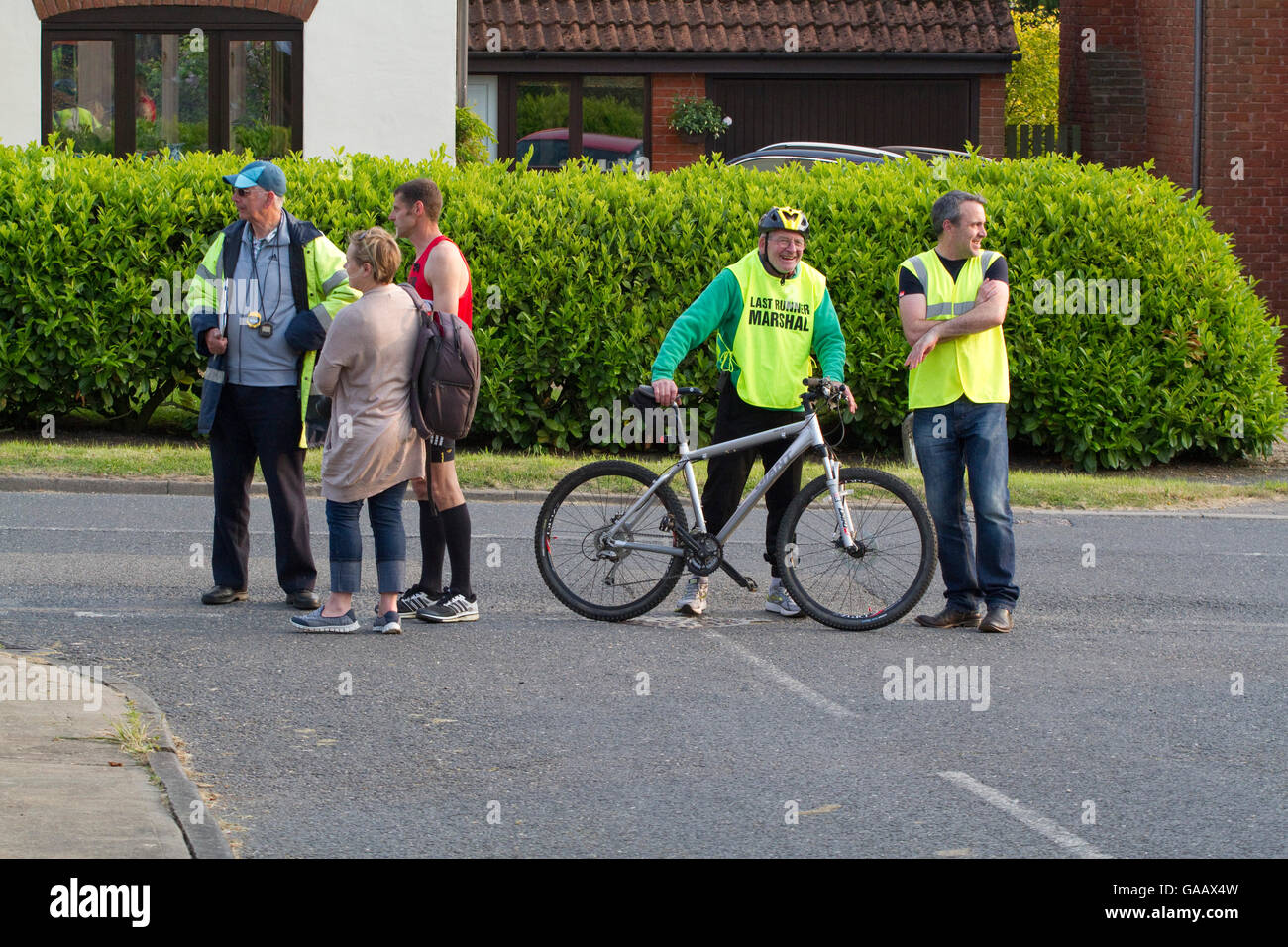 Marshals and stewards wait for the start of a 10km running road race ...