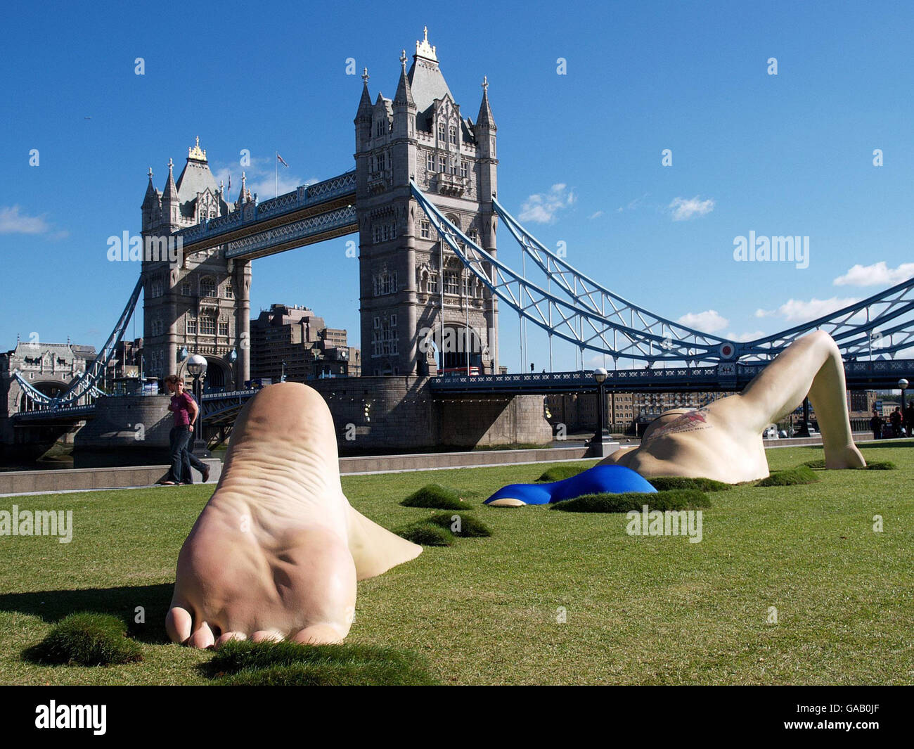 A gigantic, life-like statue of a man swimming through the pavement on ...