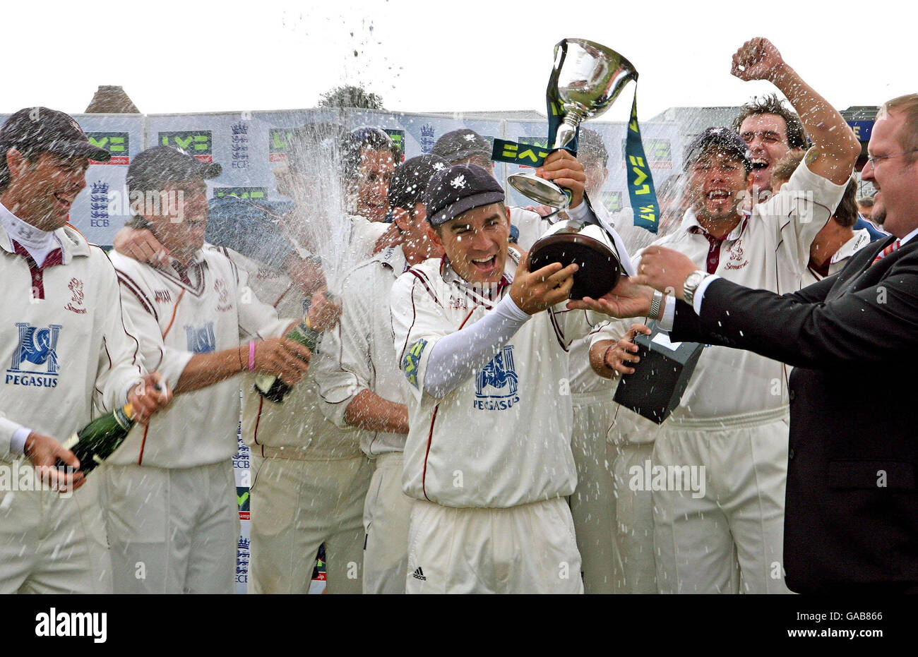 Somerset captain Justin Langer (centre) collects the trophy after ...